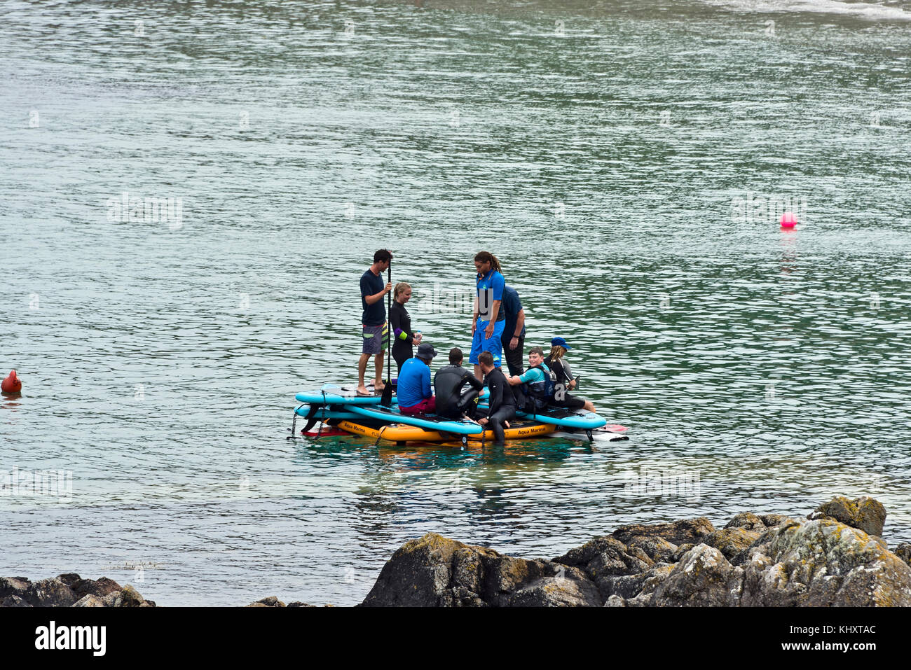 paddle boarding training group with raft of boards jumping through hole ...