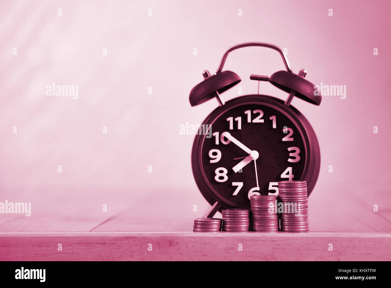 Alarm clock and step of coins stacks on working table, time for savings ...