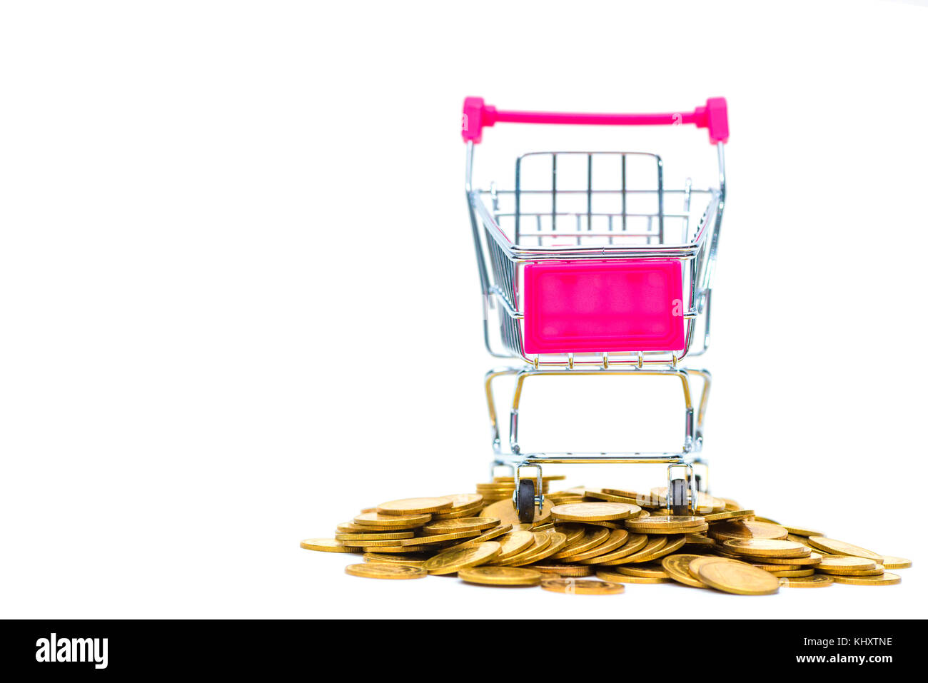 Stack of coins and shopping cart or supermarket trolley on white ...