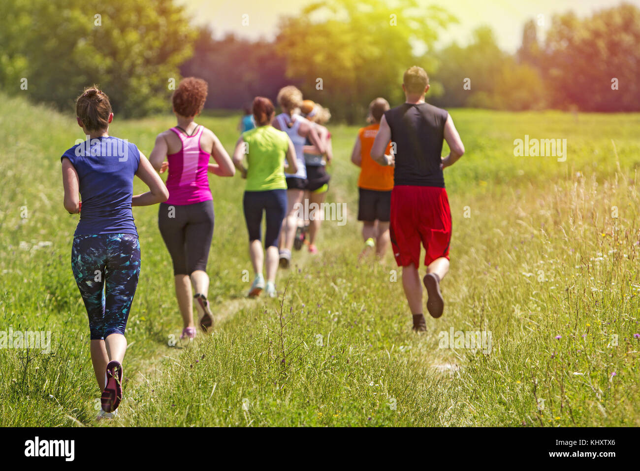 Group of young athlete running marathon outdoors in sunset Stock Photo ...