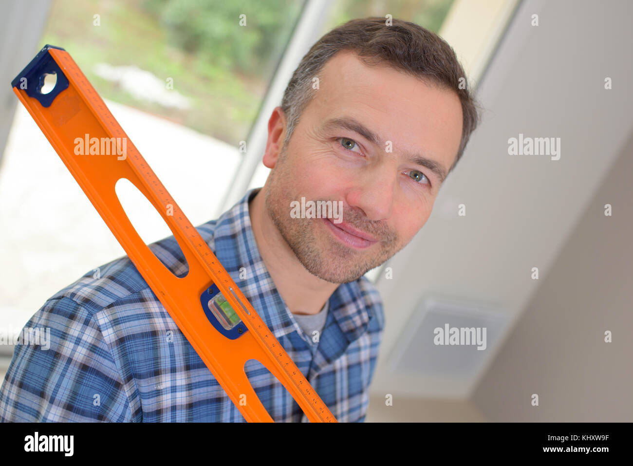 Handyman holding a spirit level Stock Photo - Alamy