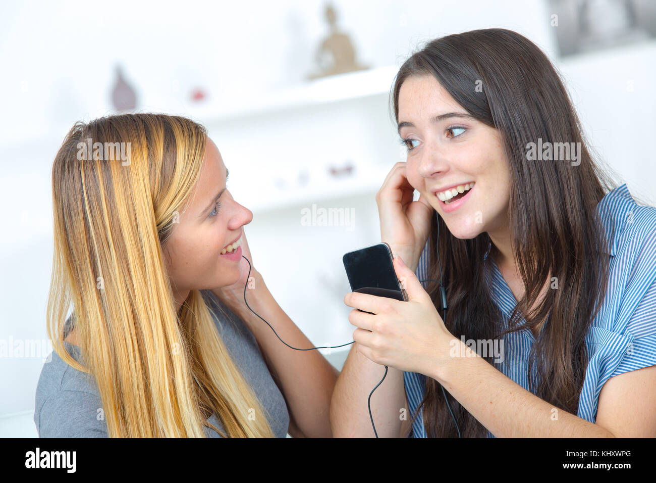 young women sharing the music Stock Photo - Alamy