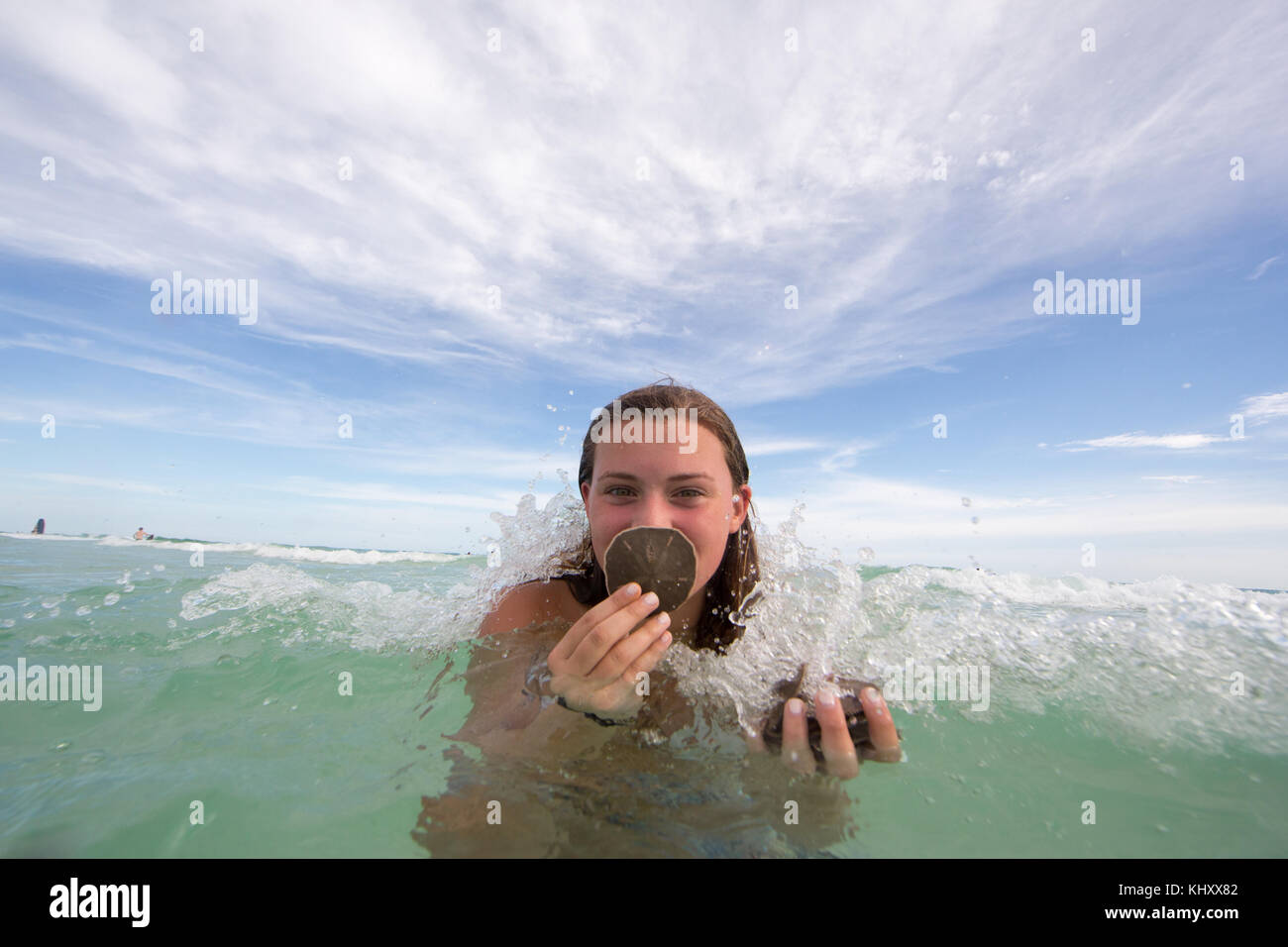 Portrait of young woman in water, holding shells Stock Photo - Alamy