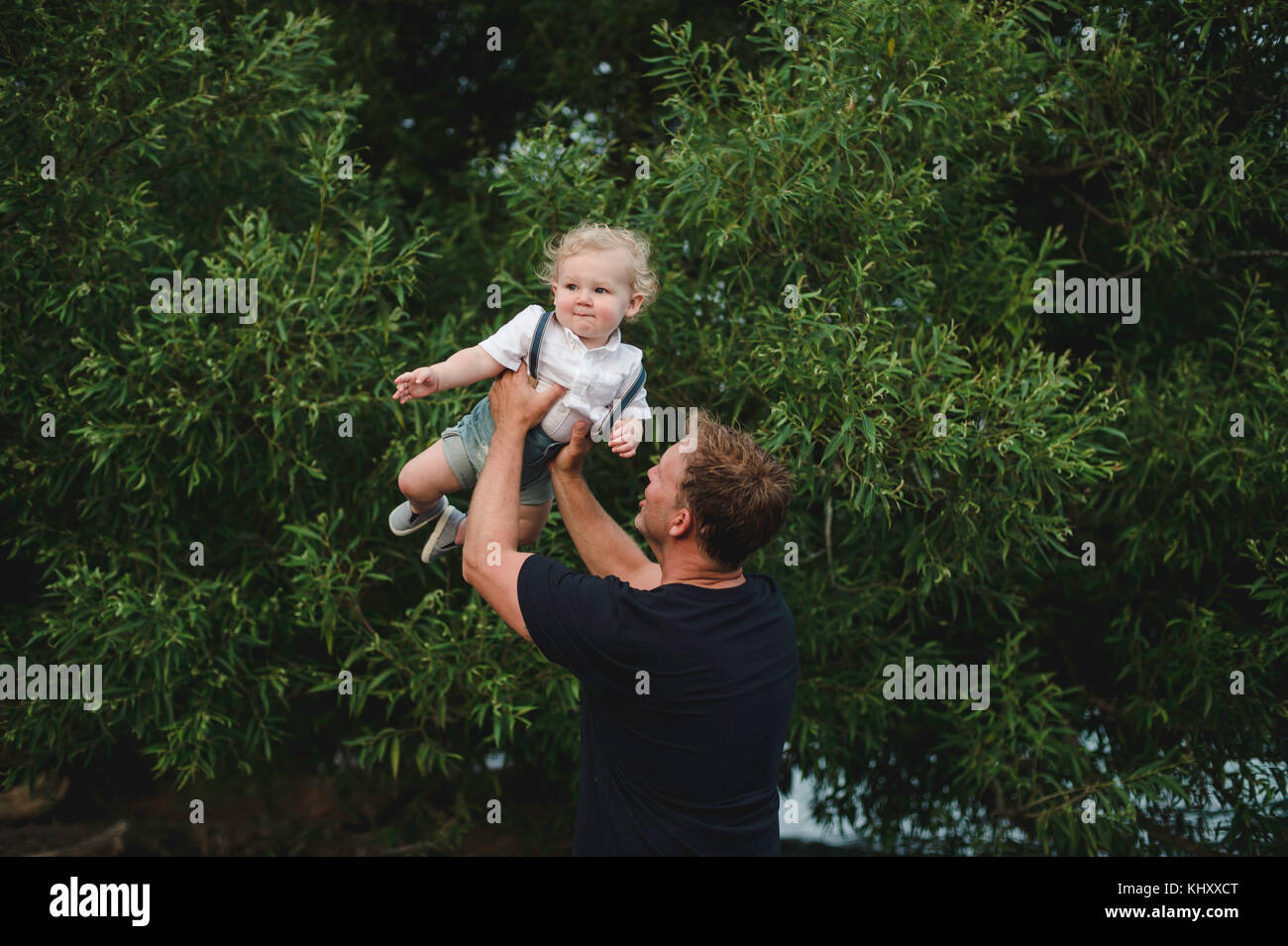 Mature man lifting up toddler son Stock Photo - Alamy