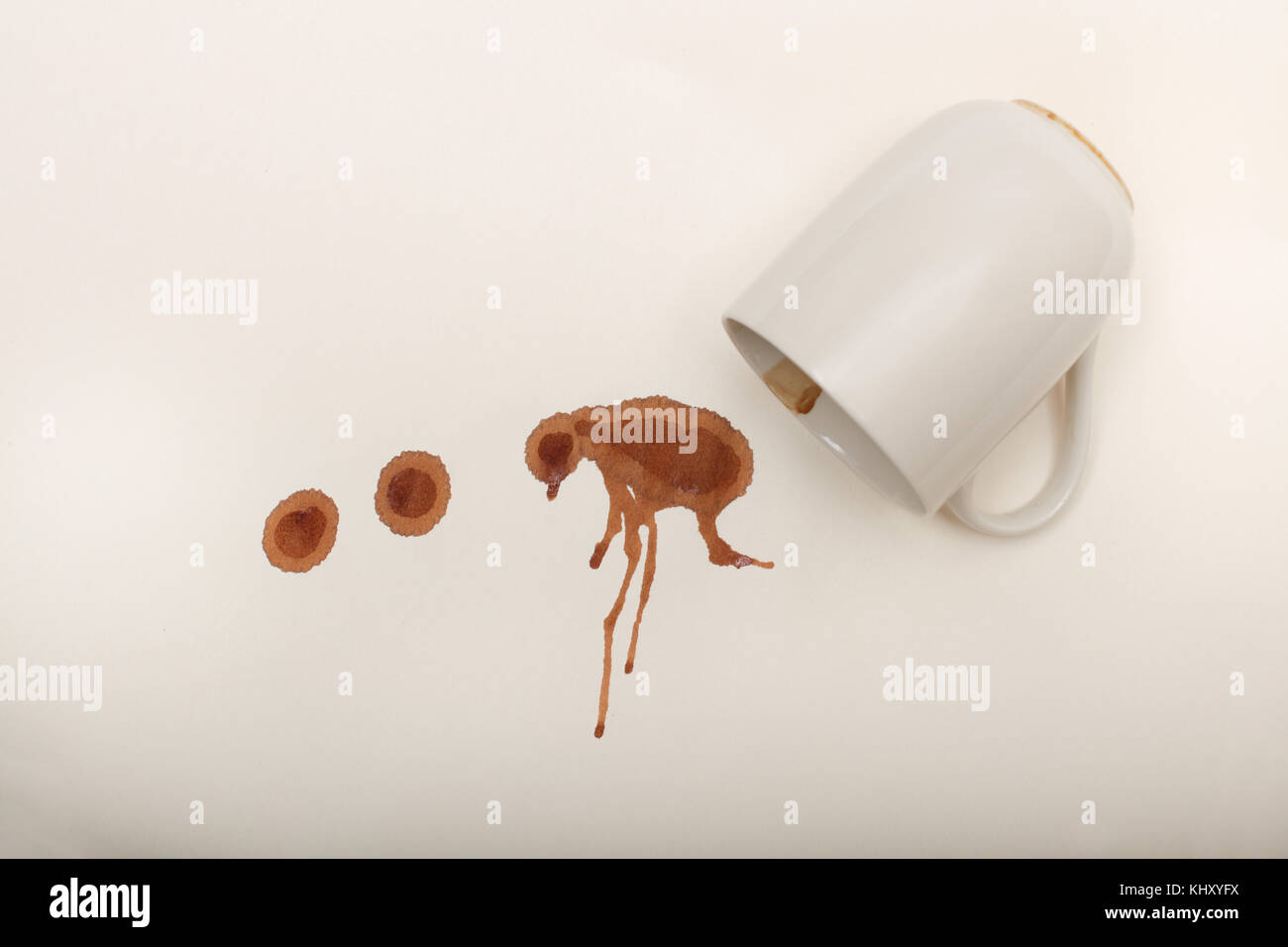Close up view of empty coffee mug with wet coffee drops on white paper ...