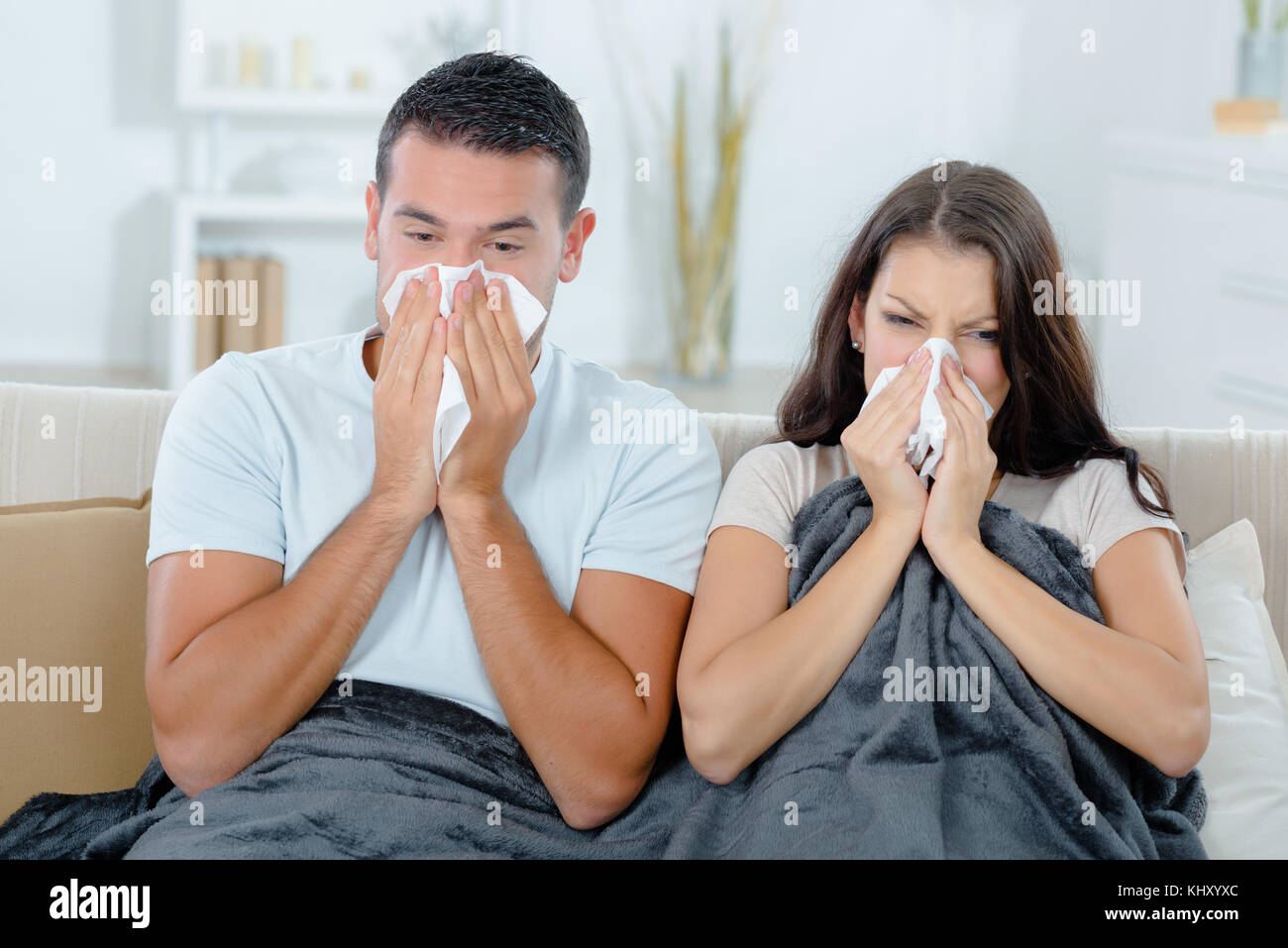 young couple blowing their nose in tissue at home Stock Photo - Alamy