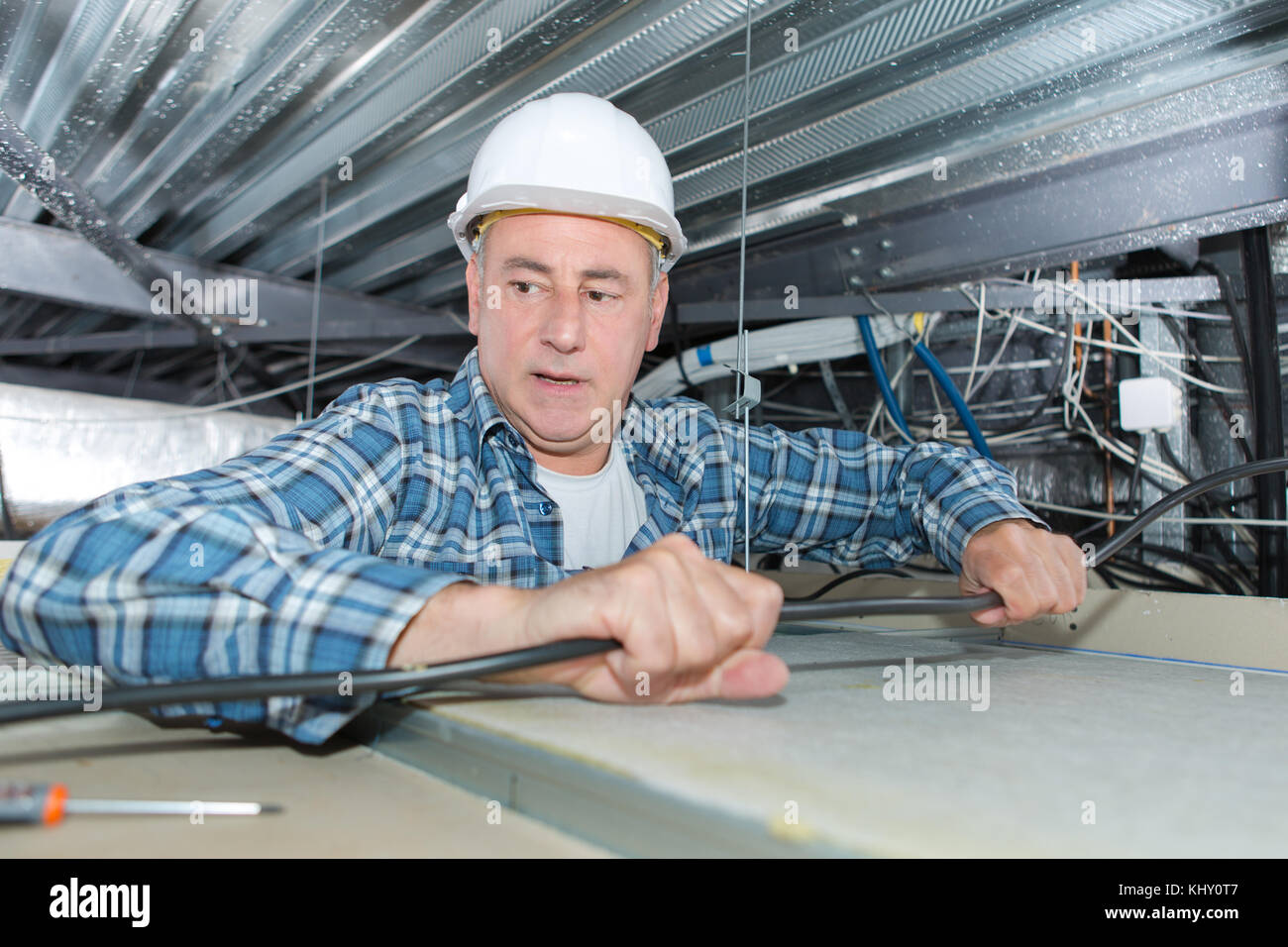 man fixing the cables in the ceiling Stock Photo - Alamy