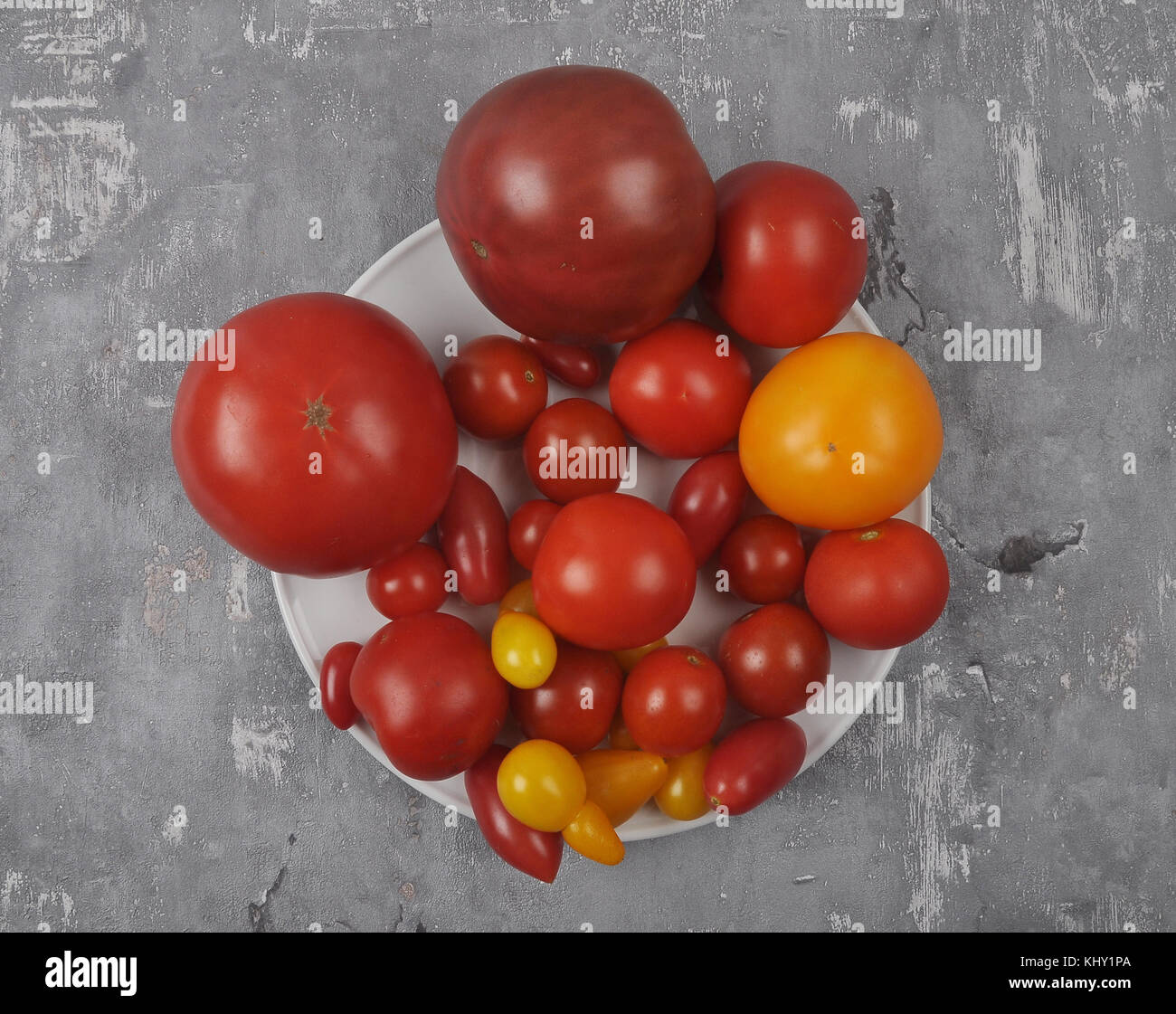 Variety of tomato cultivars on plate and concrete Stock Photo - Alamy