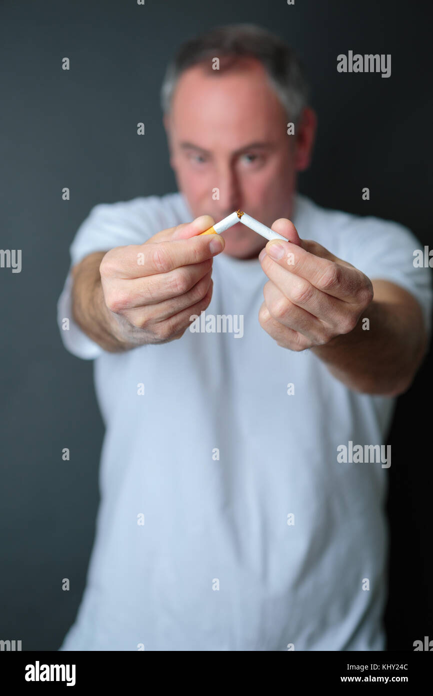 man breaking cigarette as a gesture of quitting smoking Stock Photo - Alamy