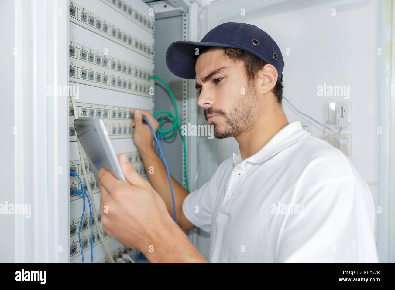 focused electrician applying safety procedure while working on ...