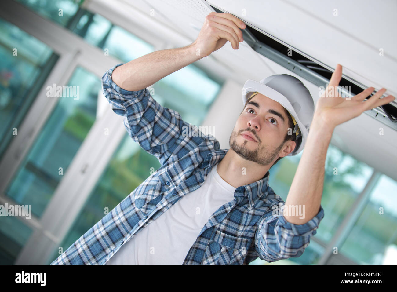 contractor replacing overhead ceiling panel Stock Photo - Alamy