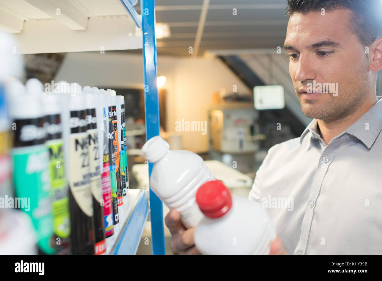 male customer comparing solvent products in hardware store Stock Photo ...