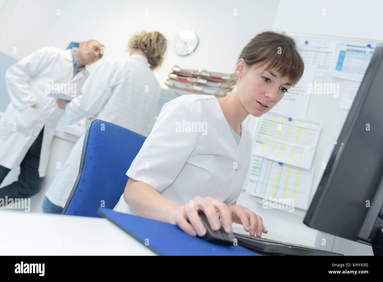 female doctor using a computer to write a repport Stock Photo - Alamy