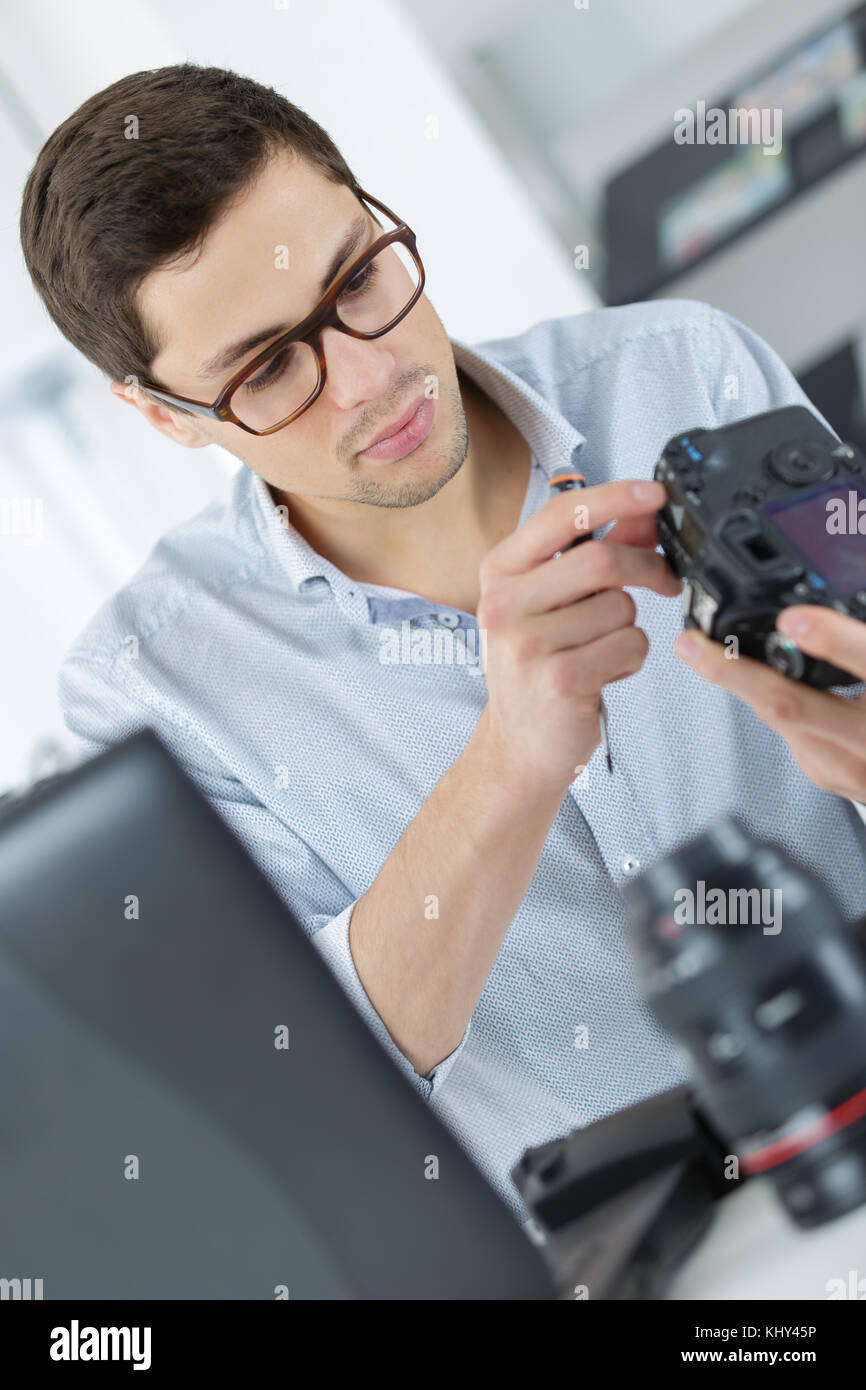 a happy worker technician at work with computer and camera Stock Photo ...