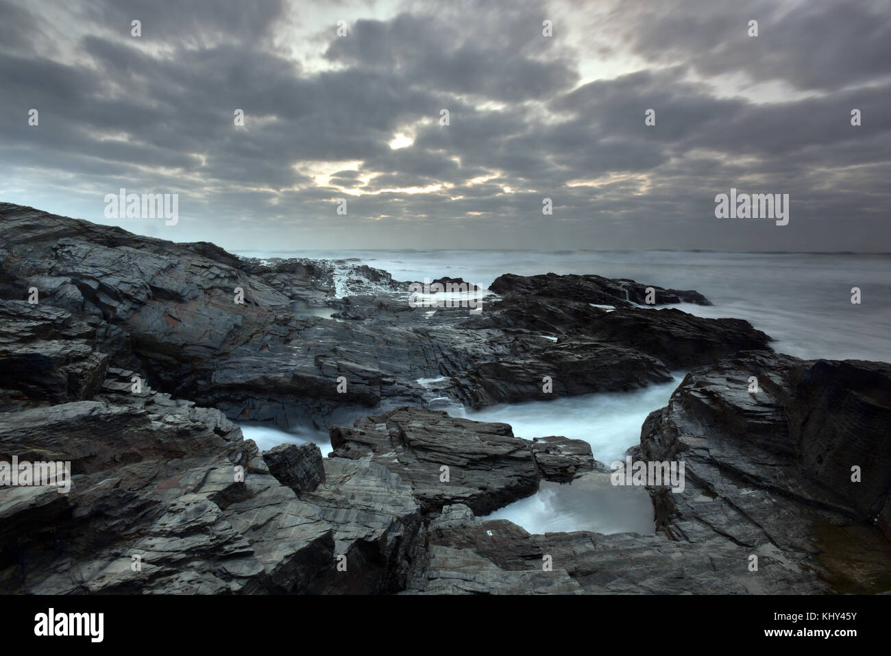 A beautiful atmospheric seascape with rocks and spray under a ...