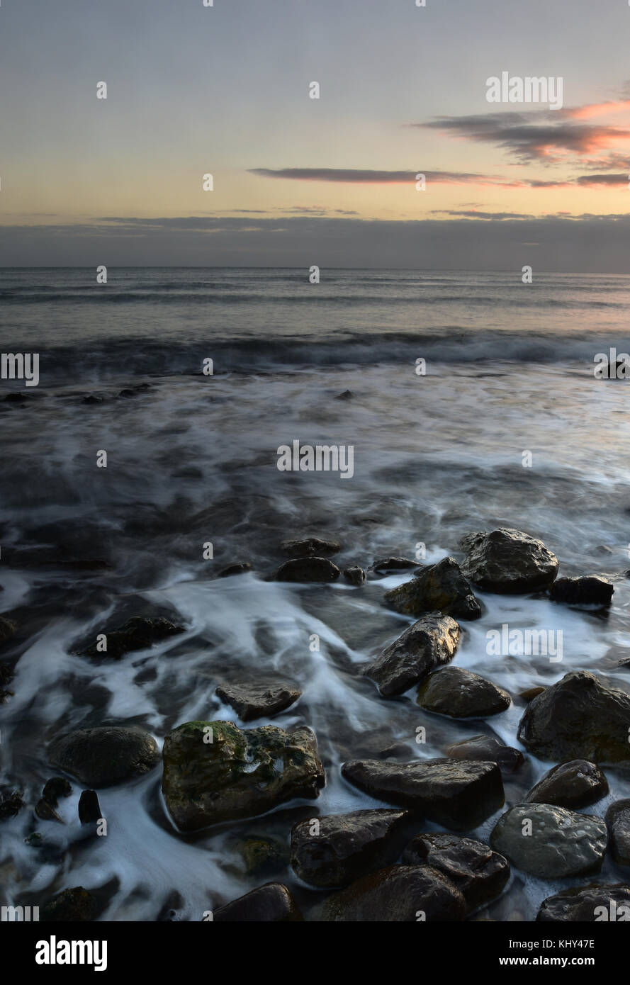 A beautiful an atmospheric seascape with the waves washing over rocks ...