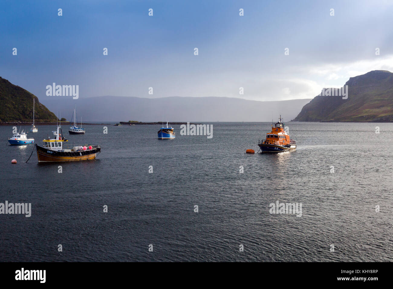 Assorted colourful boats and the Portree lifeboat at anchor in Portree ...