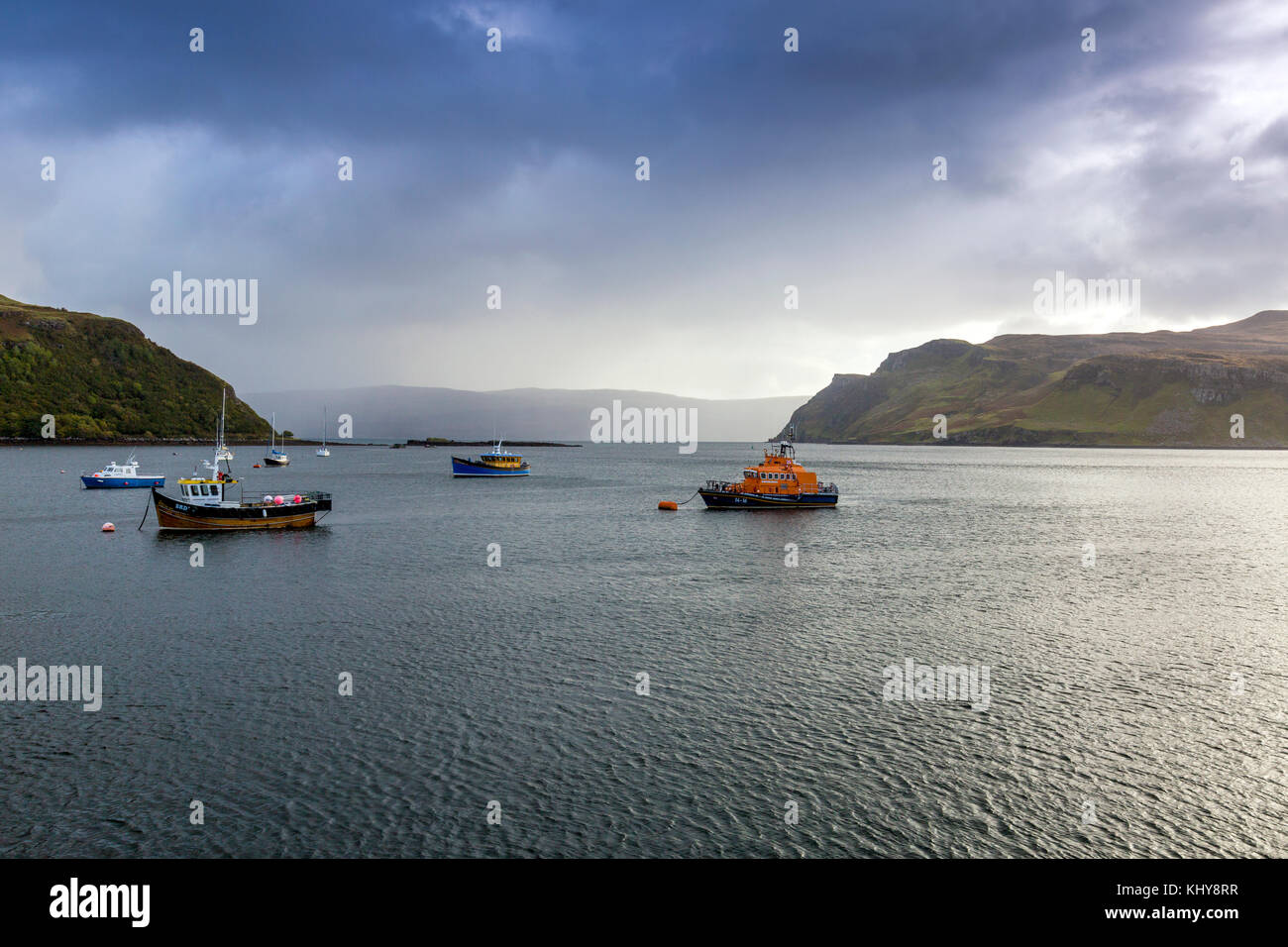 Assorted colourful boats and the Portree lifeboat at anchor in Portree ...