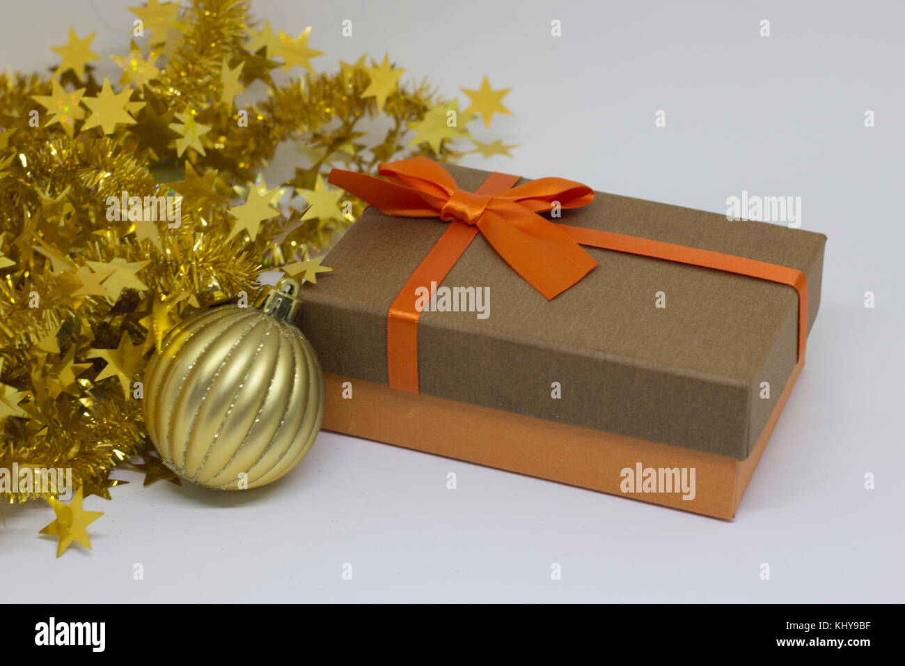 Brown gift box and golden ball on white background Stock Photo - Alamy