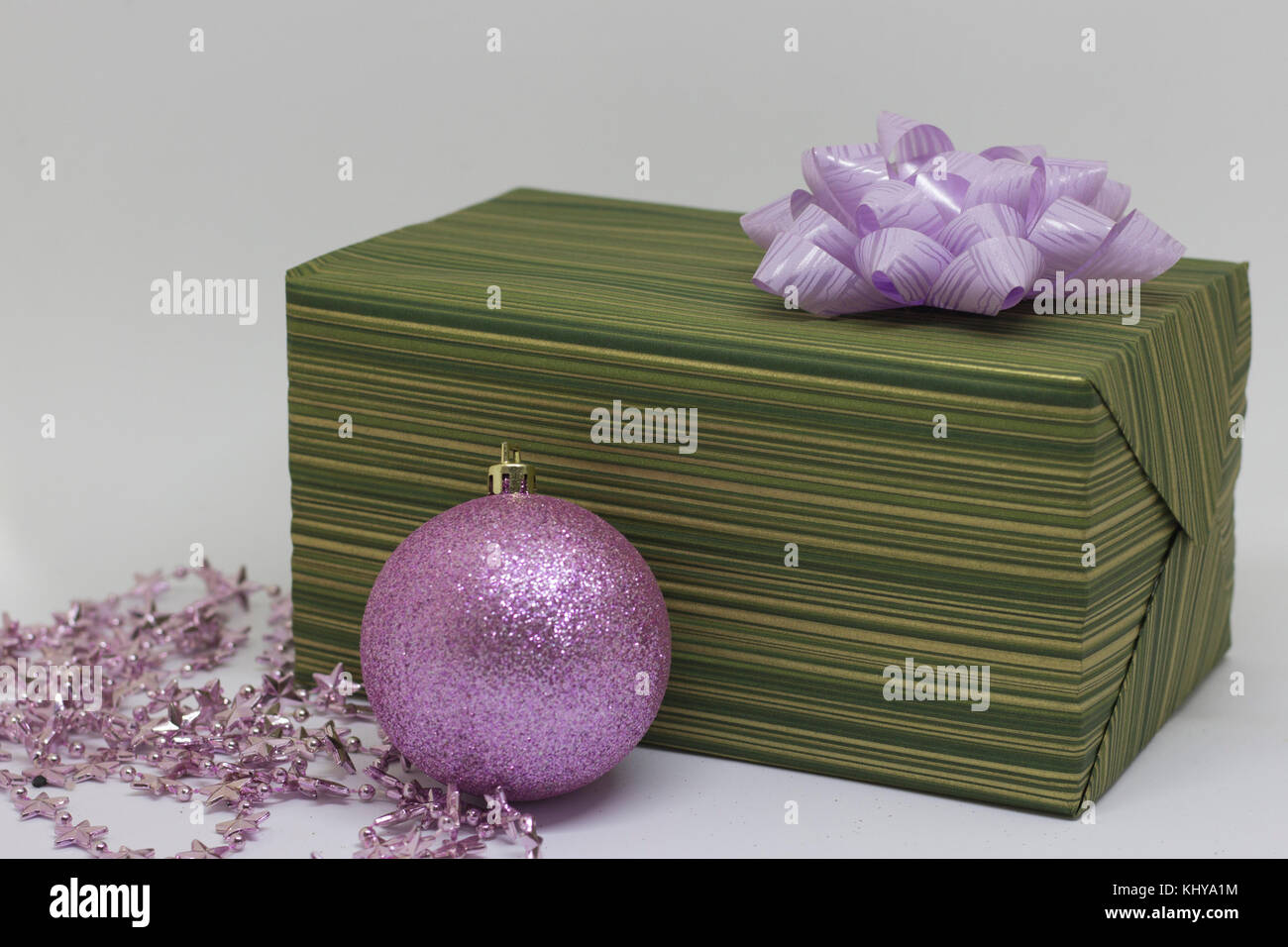 Green box with a lilac bow on a light background Stock Photo - Alamy