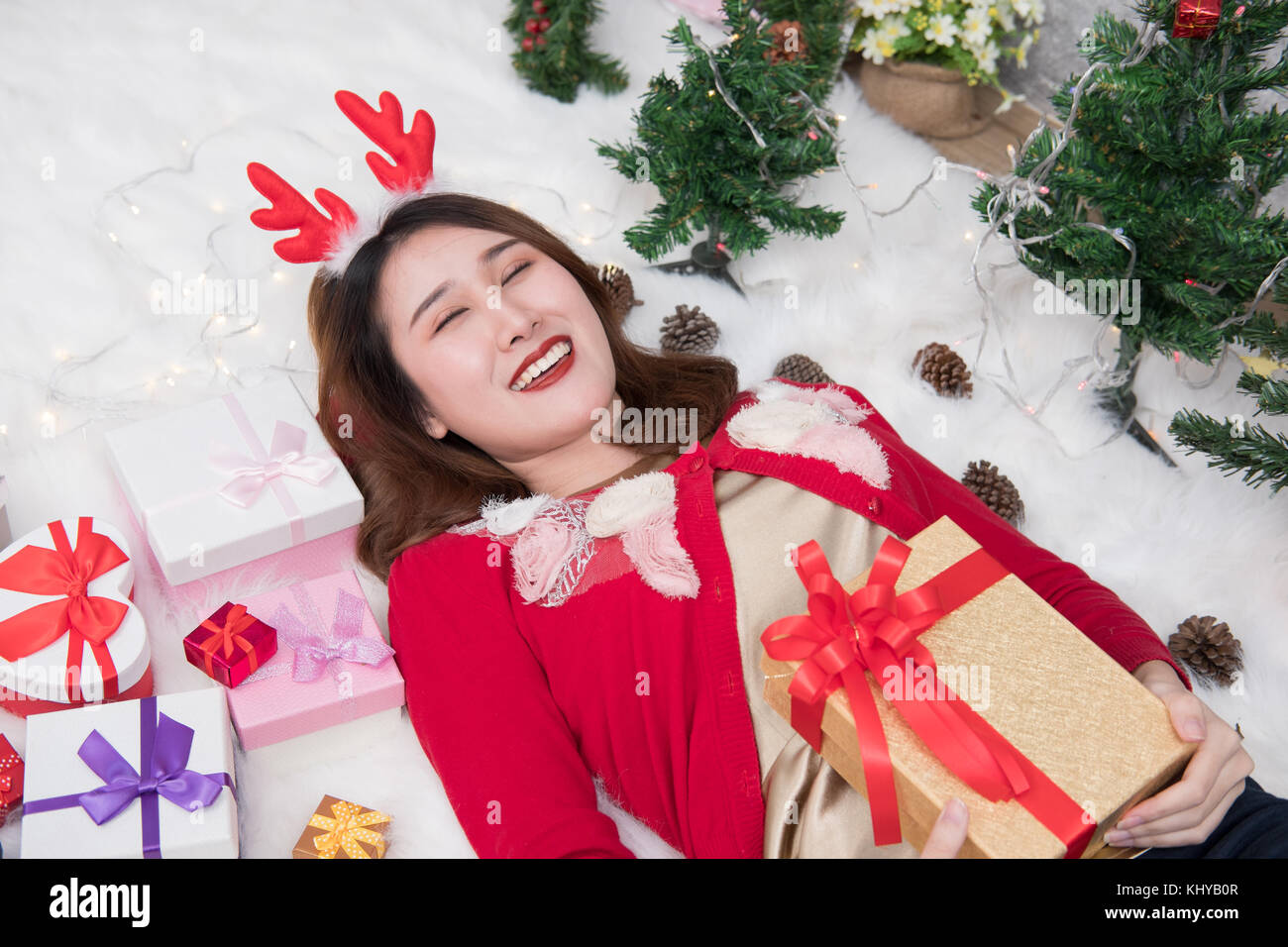 portrait of asian woman lying near christmas tree at home. girl with ...