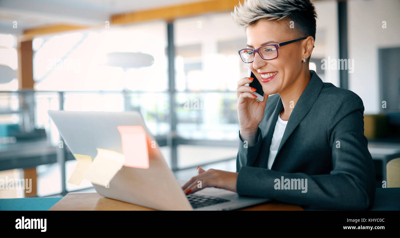 Attractive young female architect working on laptop Stock Photo - Alamy
