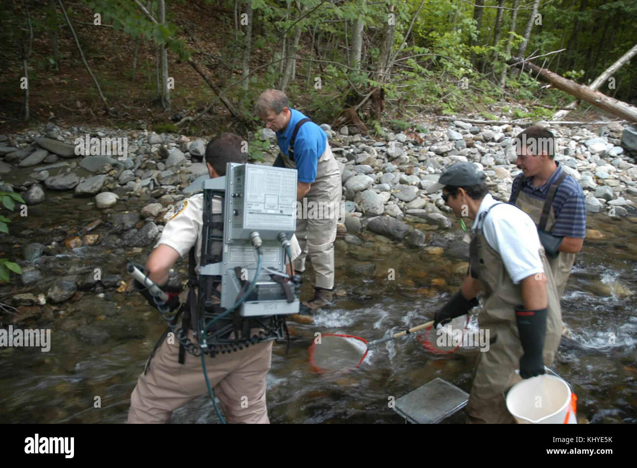 A fisherman using electric shock equipment to catch fish, highlighting ...
