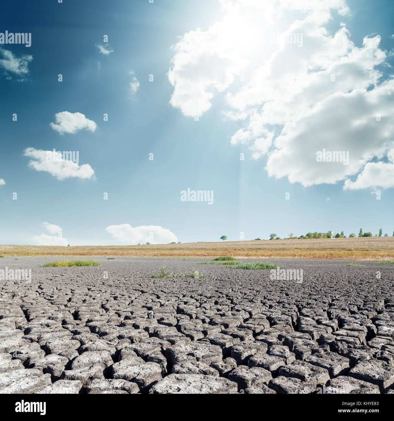 sun in clouds over drought earth Stock Photo - Alamy