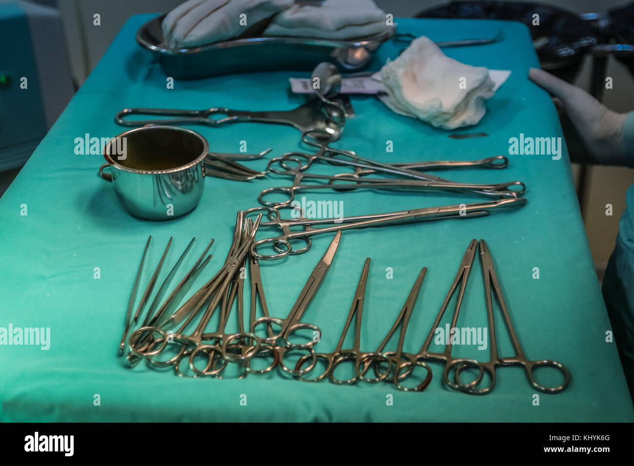 Surgeon and a nurse using forceps to stretch open an incision on a ...