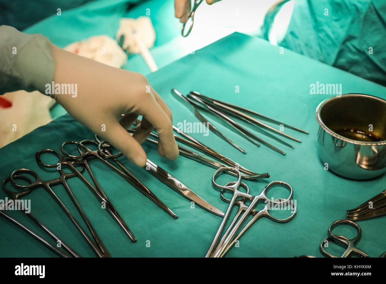 Surgeon and a nurse using forceps to stretch open an incision on a ...