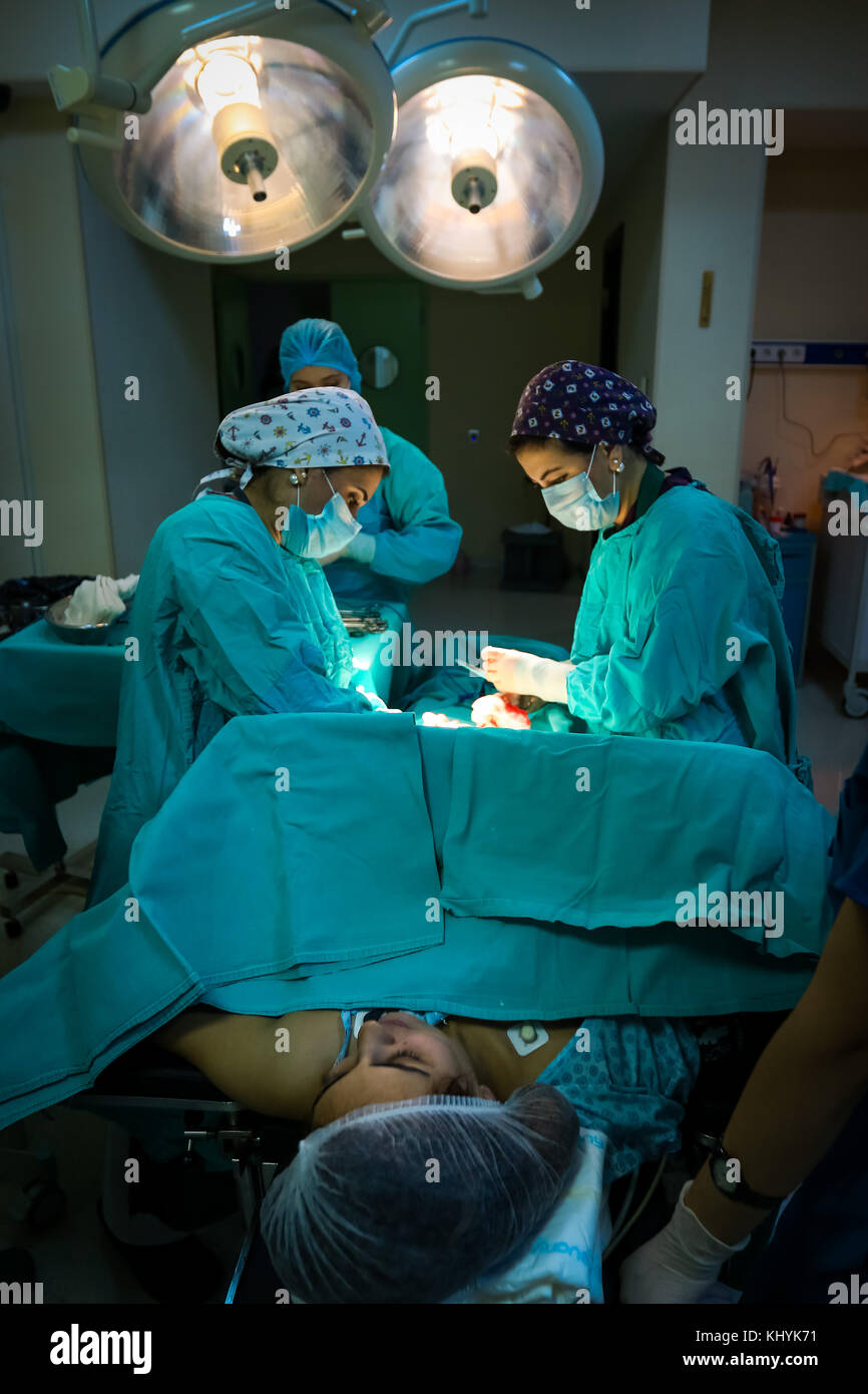 Doctors perform a Cesarean section of an operating room in a maternity ...