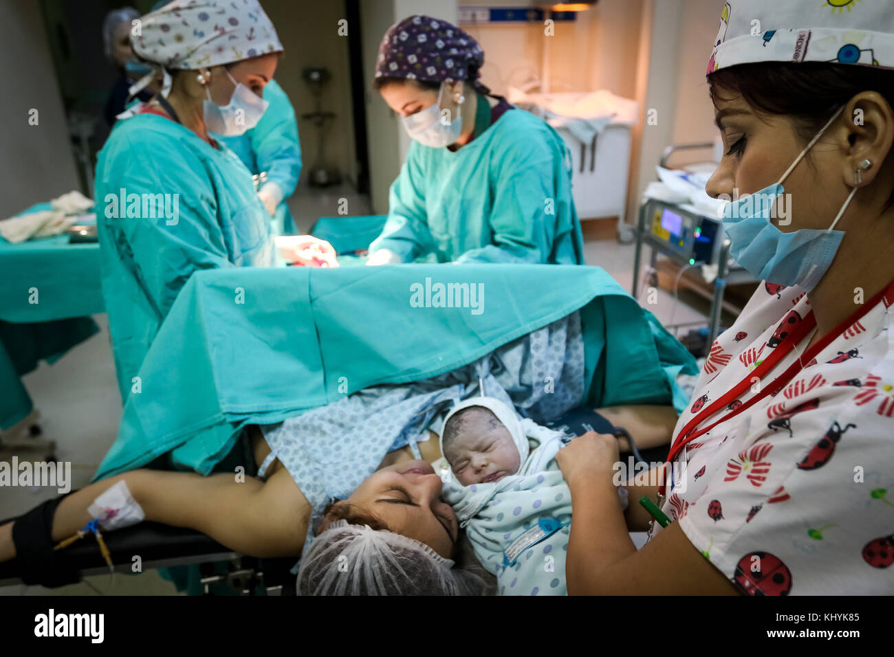 Operating room nurse showing newborn to mother Stock Photo - Alamy