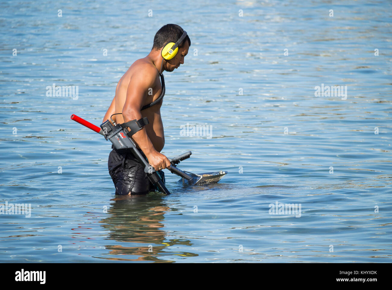 Man metal detecting with metal detector in the sea Stock Photo - Alamy