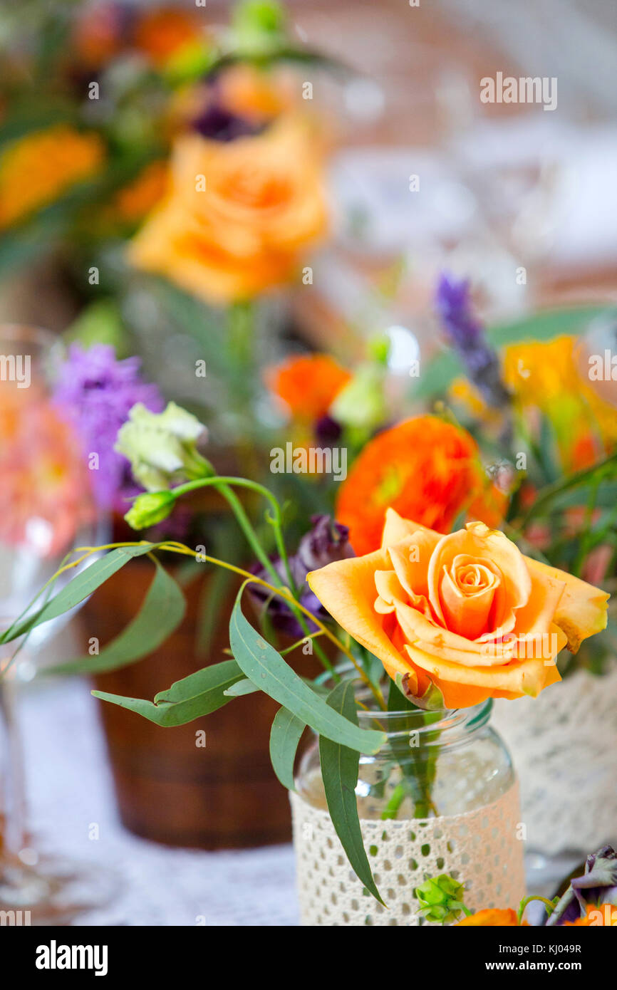 Wedding reception table with colourful variety of fresh cut flowers ...