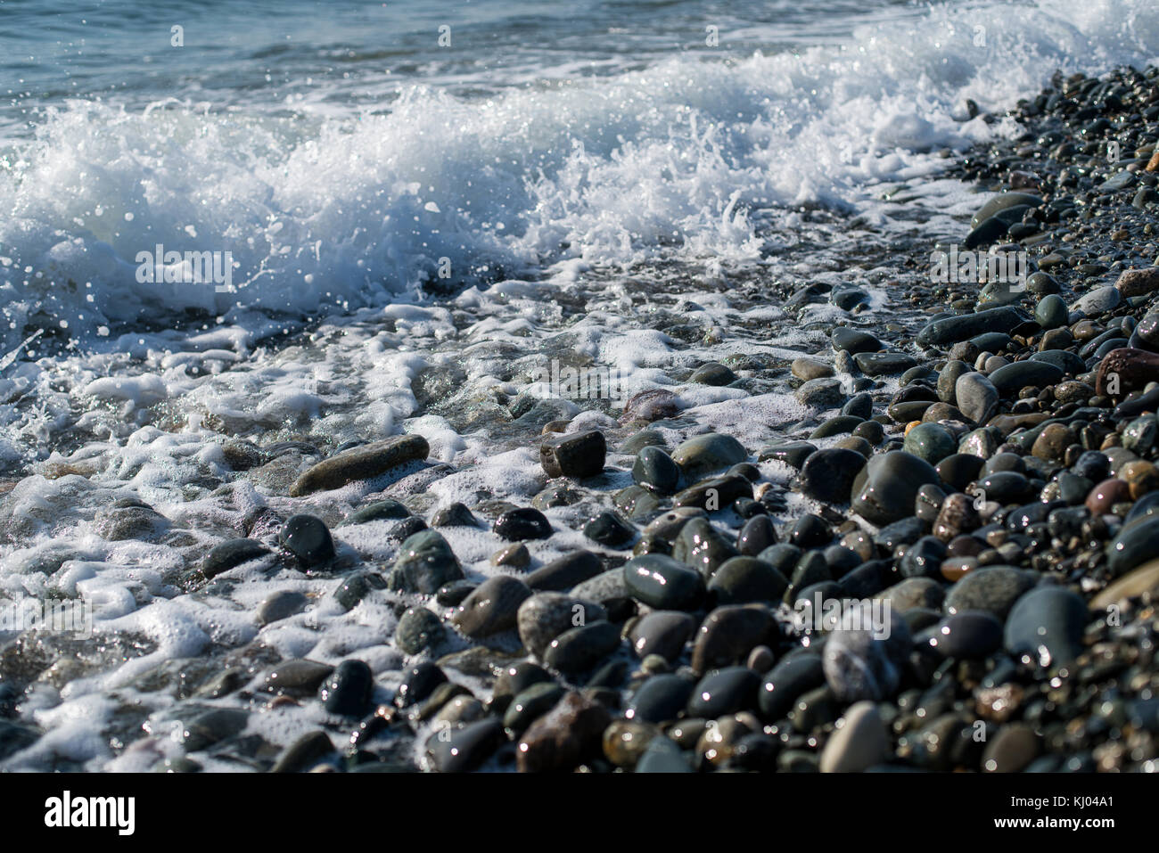 Stones on beach and sea water Stock Photo - Alamy