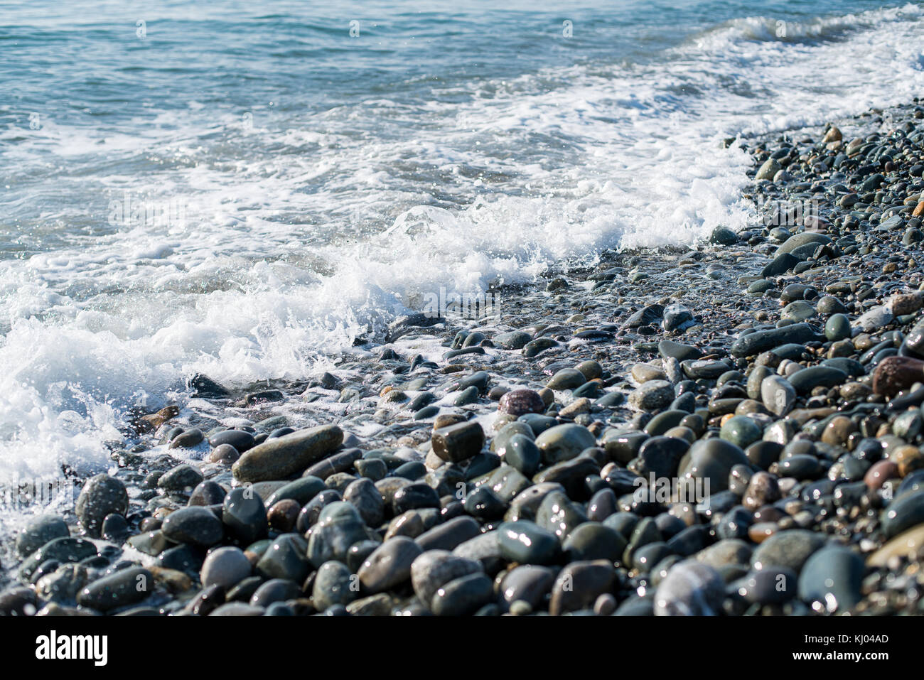 Stones on beach and sea water Stock Photo - Alamy