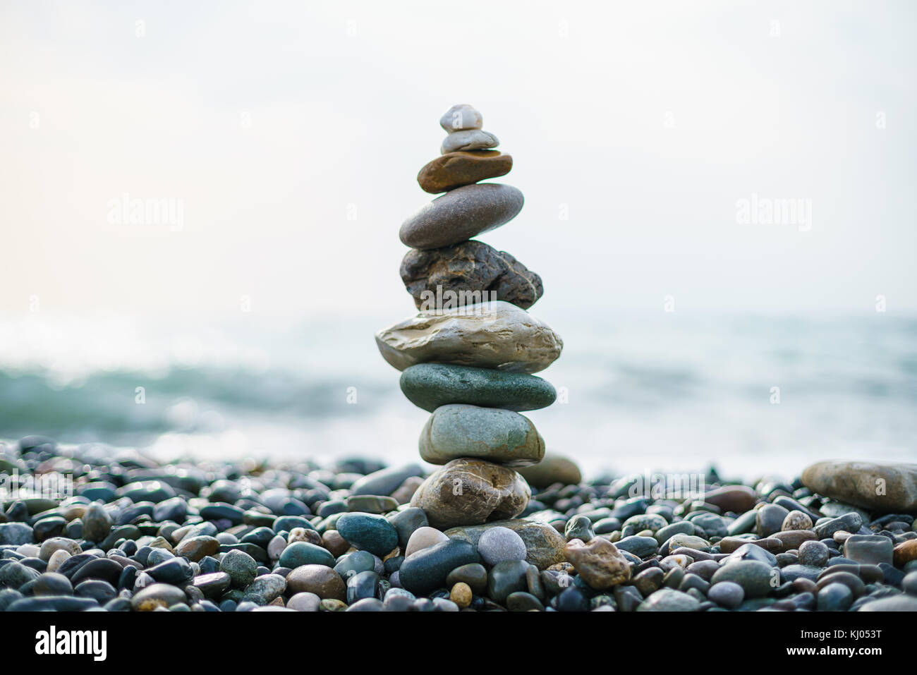 Stones pyramid on pebble beach, stability, zen, harmony, balance ...