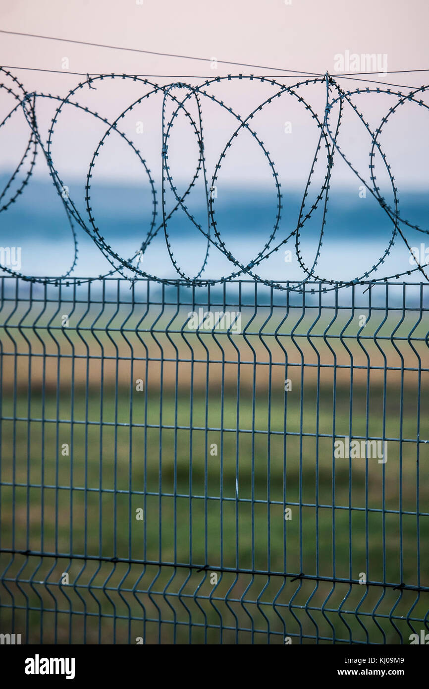 Security with a barbed wire fence Stock Photo - Alamy