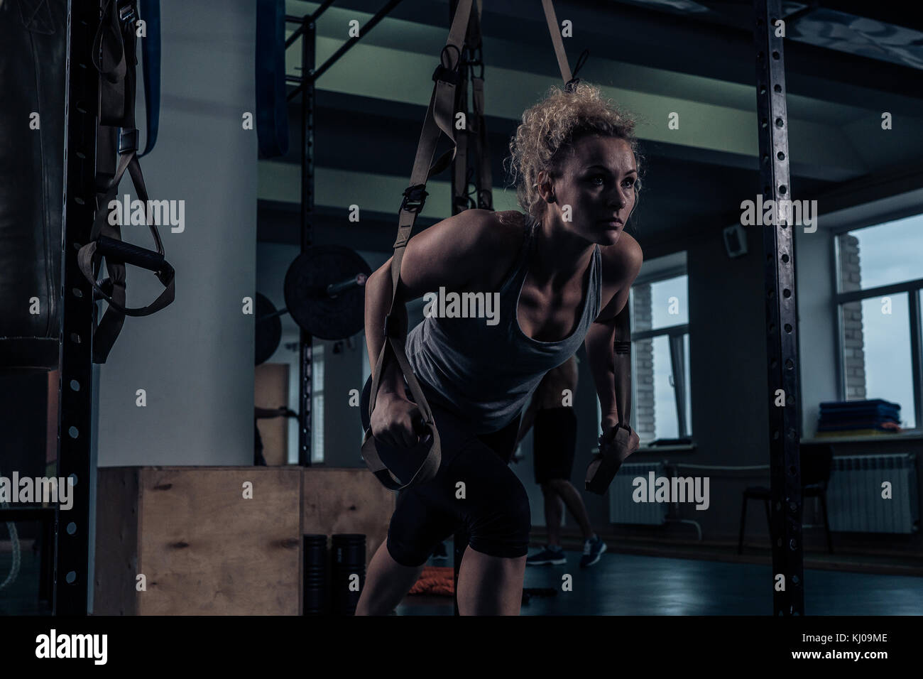 Strength exercises. A girl is doing an exercise on the back muscles in ...