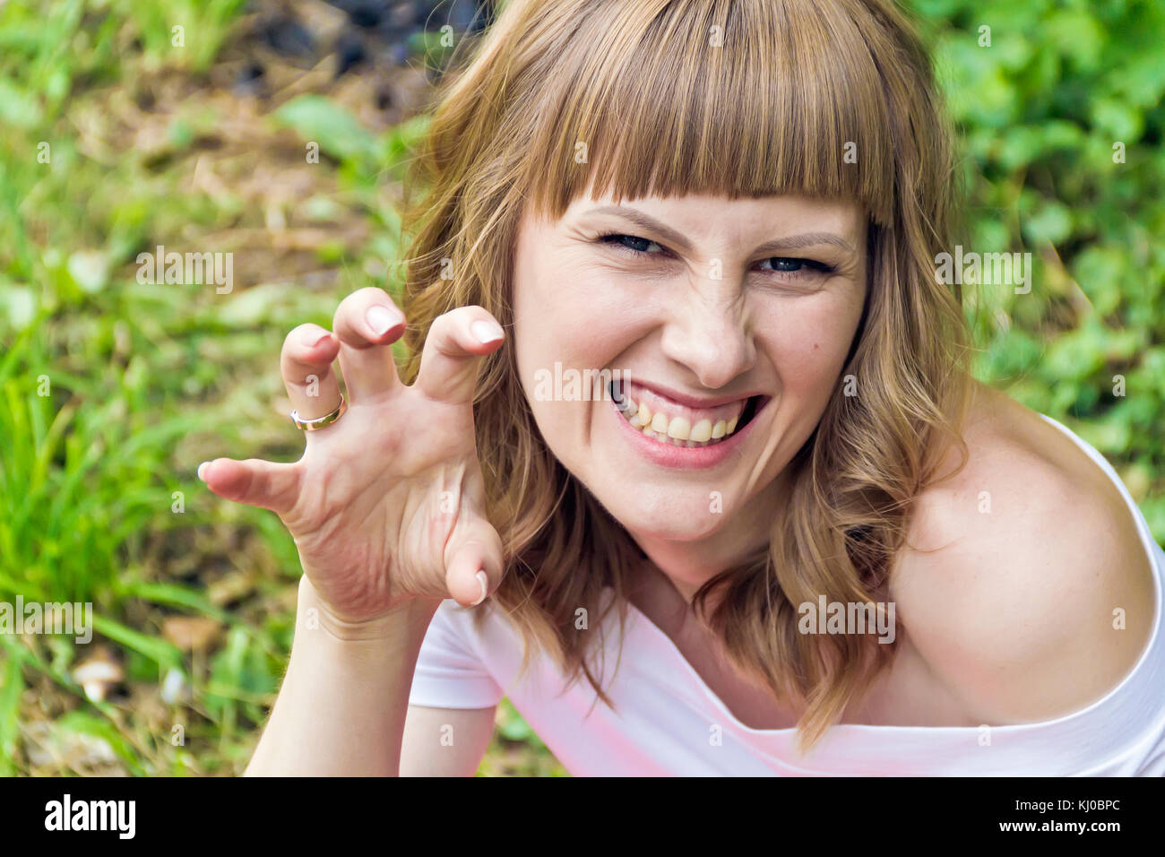 Horizontal portrait of evil woman with blond hair on summer background ...