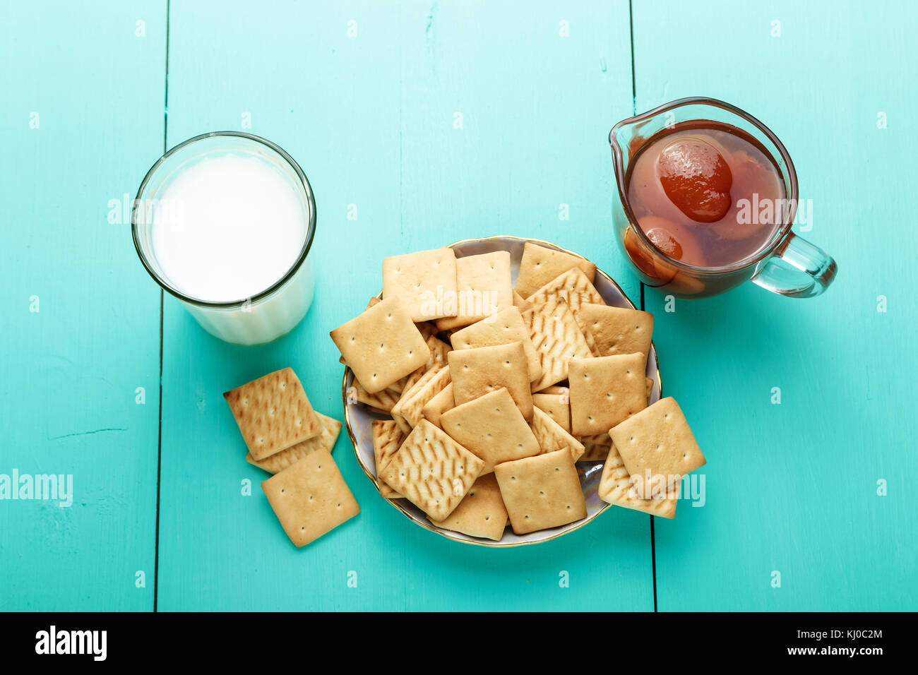 delicious breakfast crackers with jam and milk on a wooden surface ...