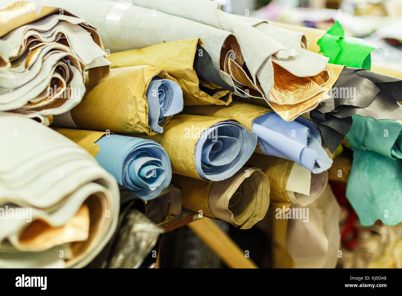 rolls of fabric wrapped in craft paper lying on each other. manufacture ...