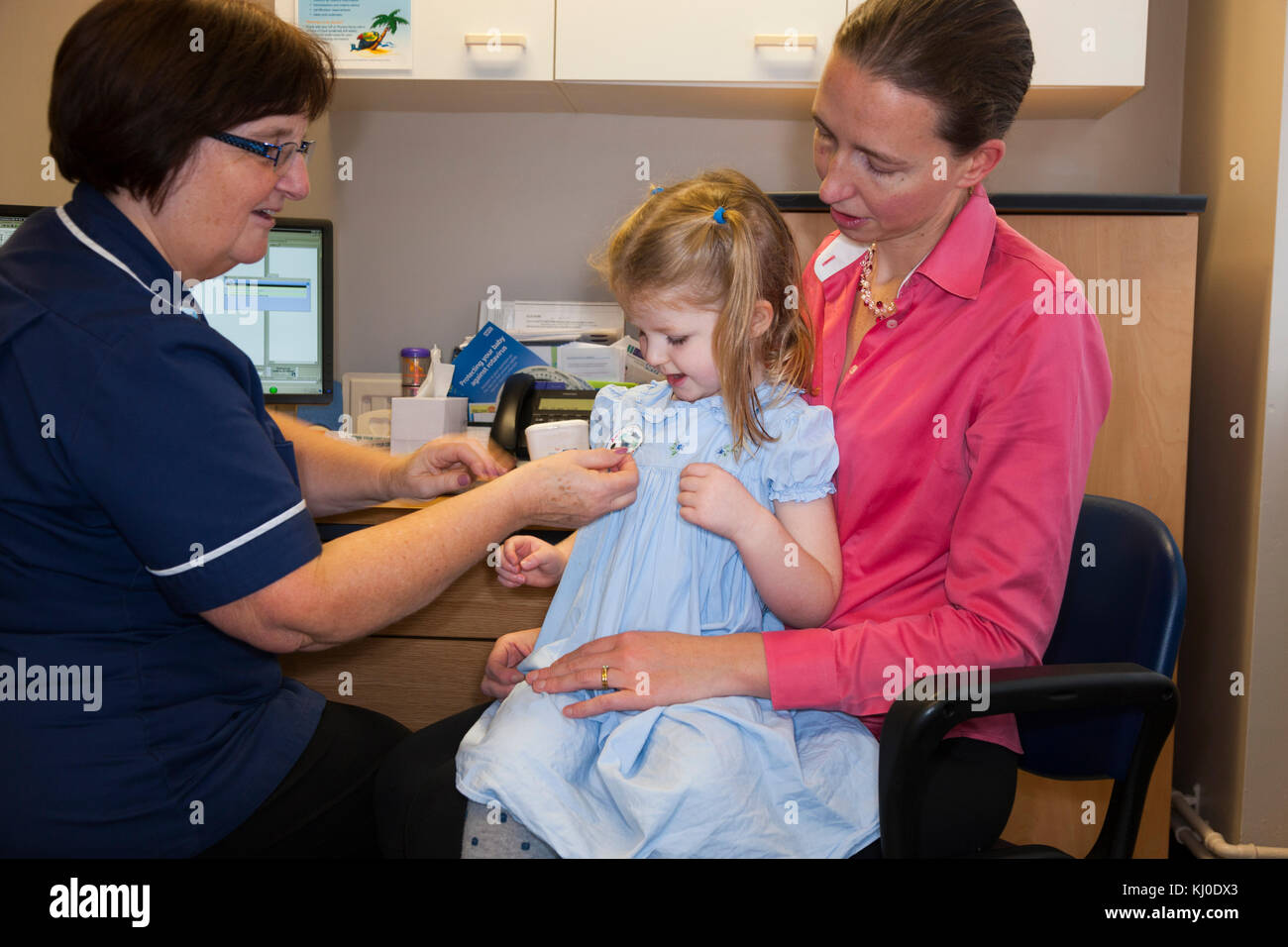 NHS Practice nurse giving a kids sticker to a 3 three year old child ...