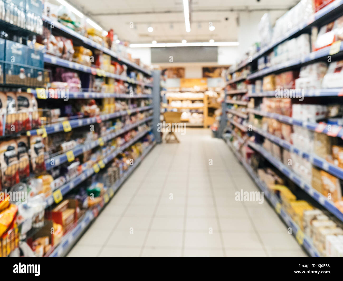 Abstract blurred supermarket aisle with colorful shelves and ...