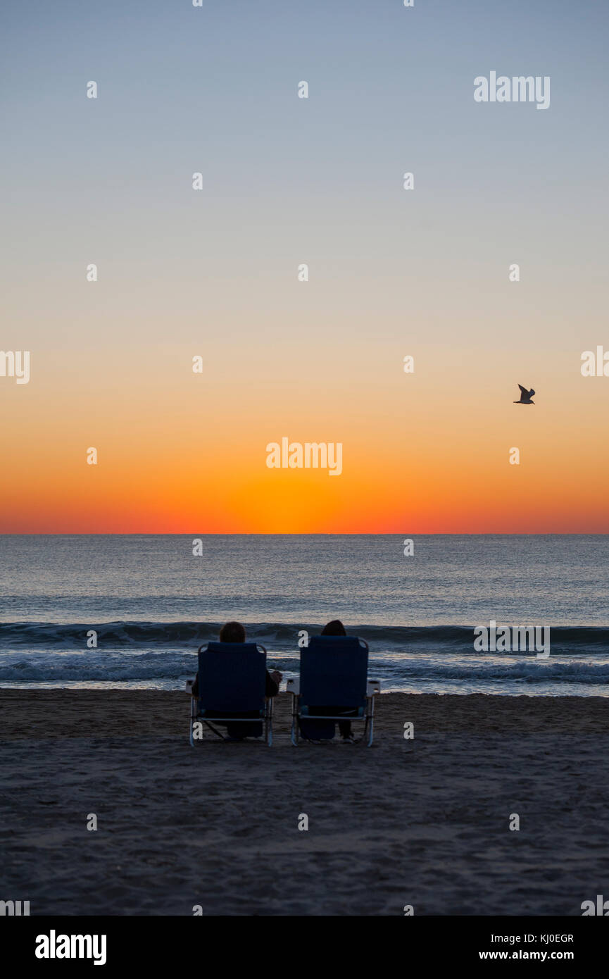 USA Maryland MD Ocean City couple watching the sunrise over the sea ...