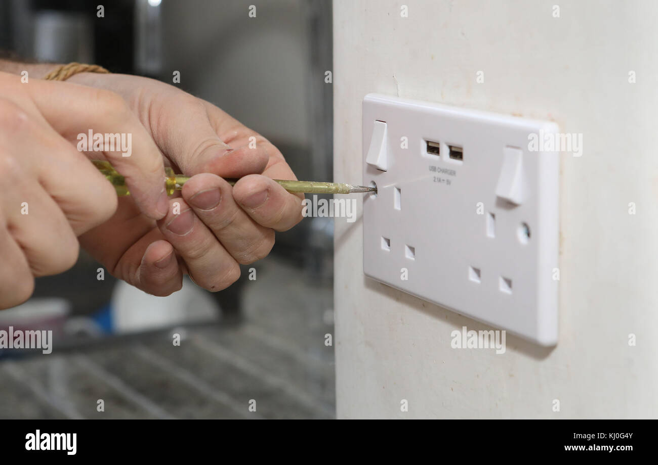 Richard Burr fitting a USB plug into a wall for his DIY feature column ...