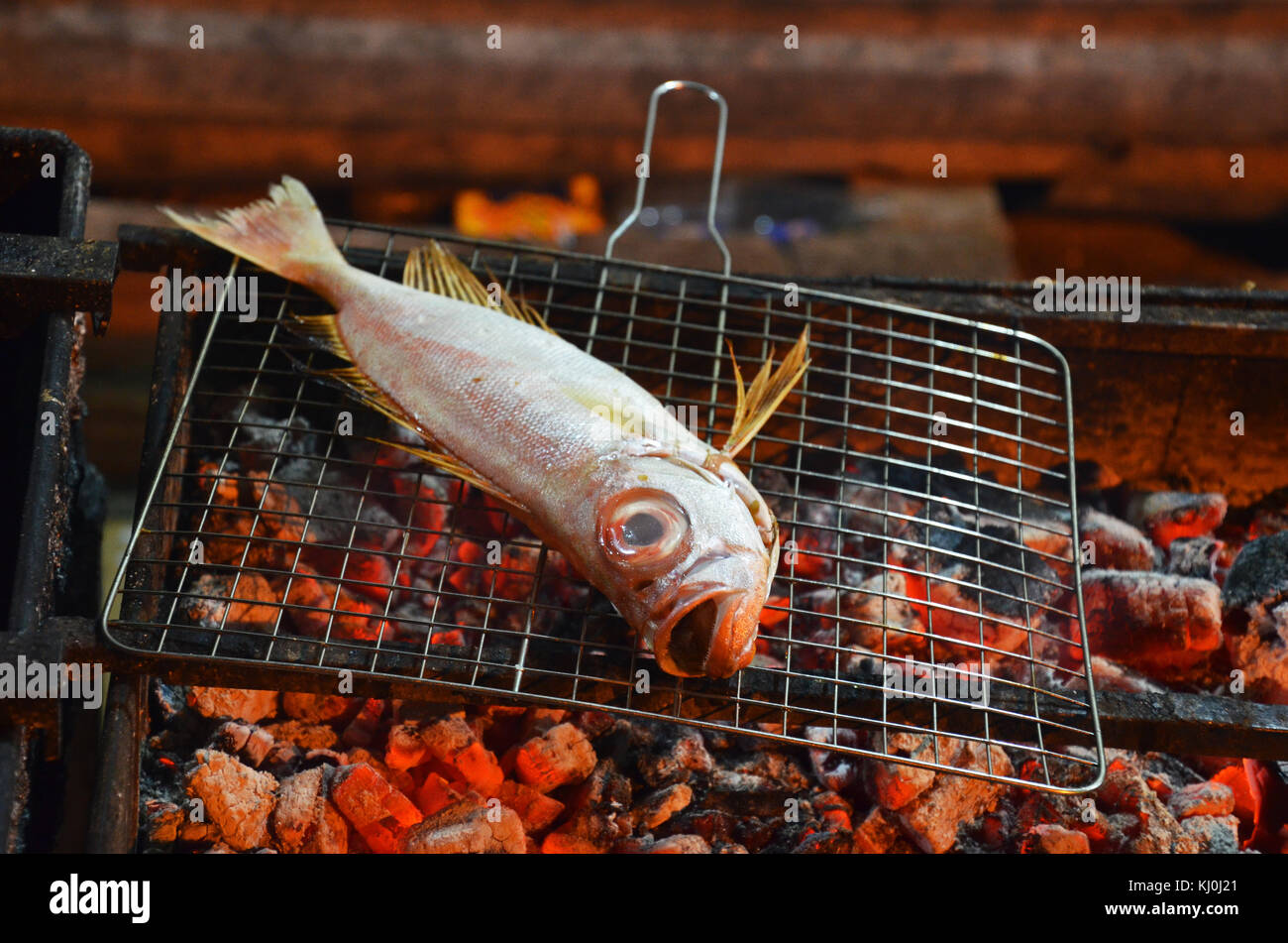 A fish cooking on a charcoal grill at a restaurant in Danang, Vietnam ...