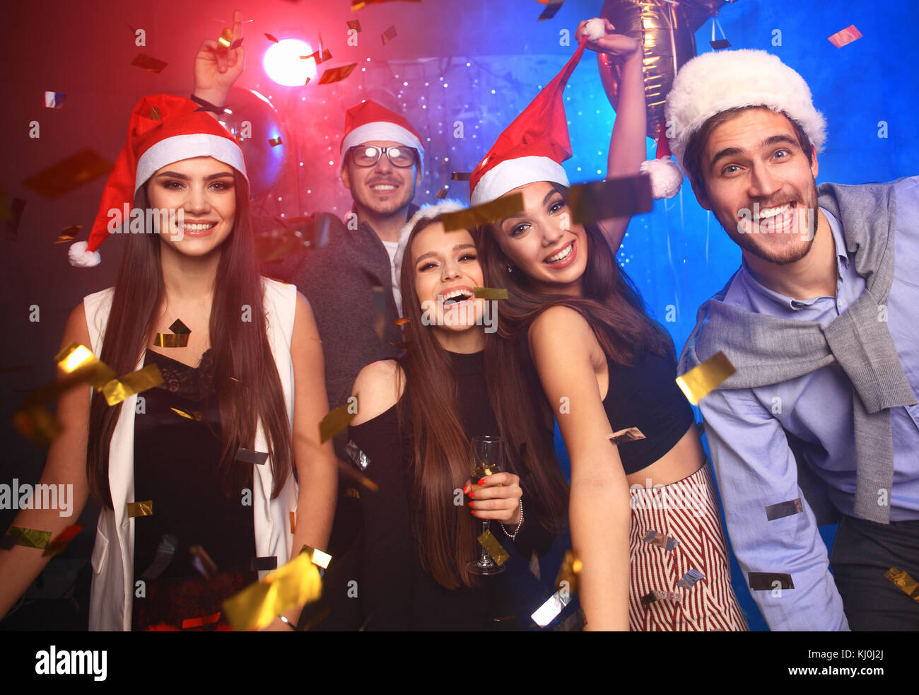 Celebrating New Year together. Group of beautiful young people in Santa ...