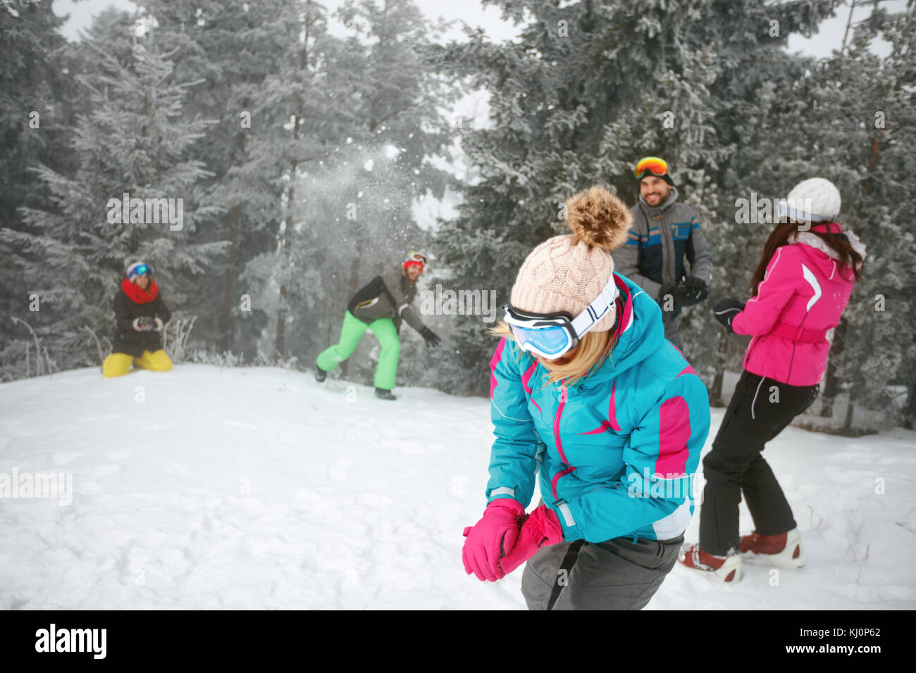 Group of friends having fun playing with snowball in the snow on a cold ...