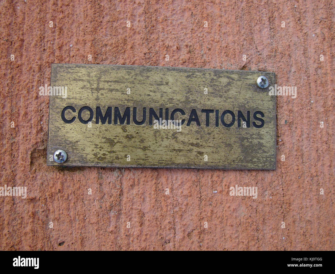 Brass plaque on concrete communications Stock Photo - Alamy